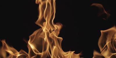 Close up to dynamic flames creating a firewall on dark background in 4K ...
