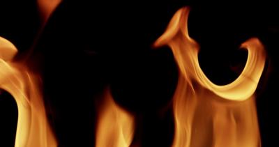 Close up to dynamic flames creating a firewall on dark background in 4K ...