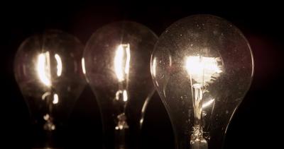 glowing bulb bulbs falling down hanging on string grey background ...