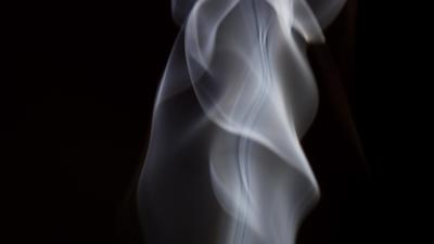 Plasma effect created by thin lines of smoke moving on dark background ...