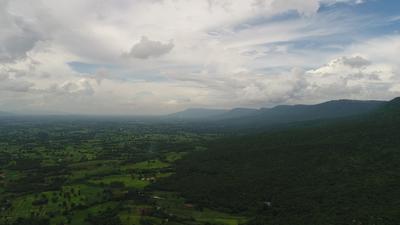 Aerial view wide shot point of view mountain with lush trees and foggy ...