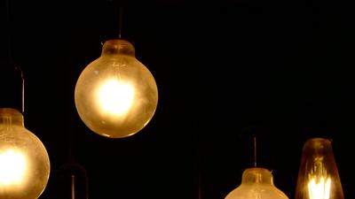 glowing bulb bulbs falling down hanging on string grey background ...